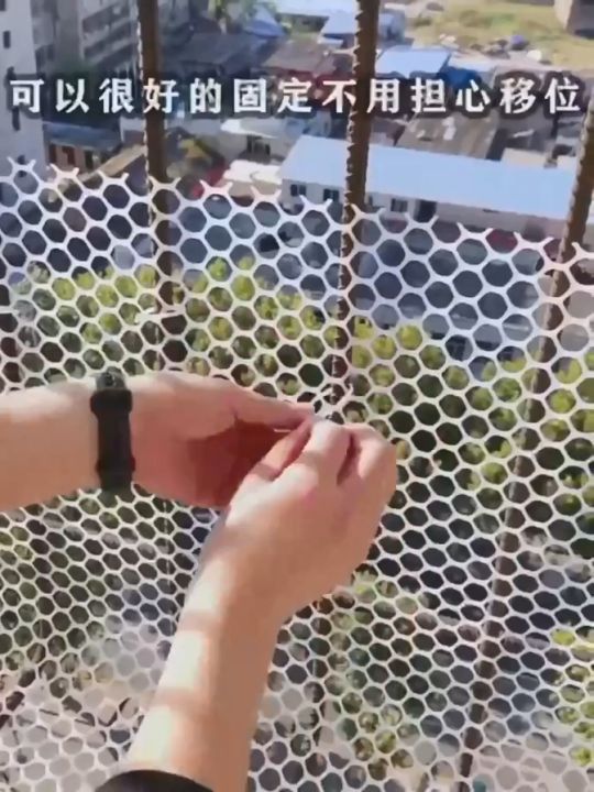 The balcony of the parabolic black plastic mesh fence against falling ...